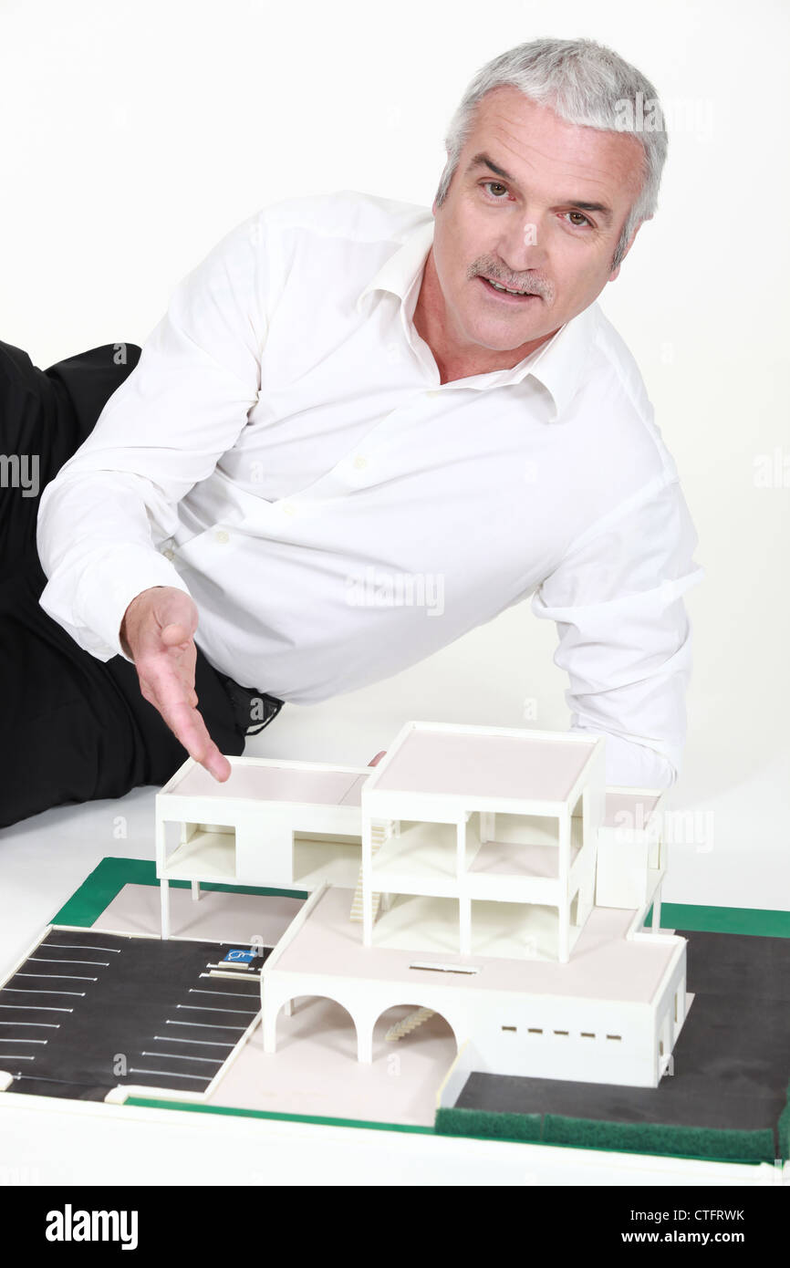 Senior architect laying by model building Stock Photo - Alamy