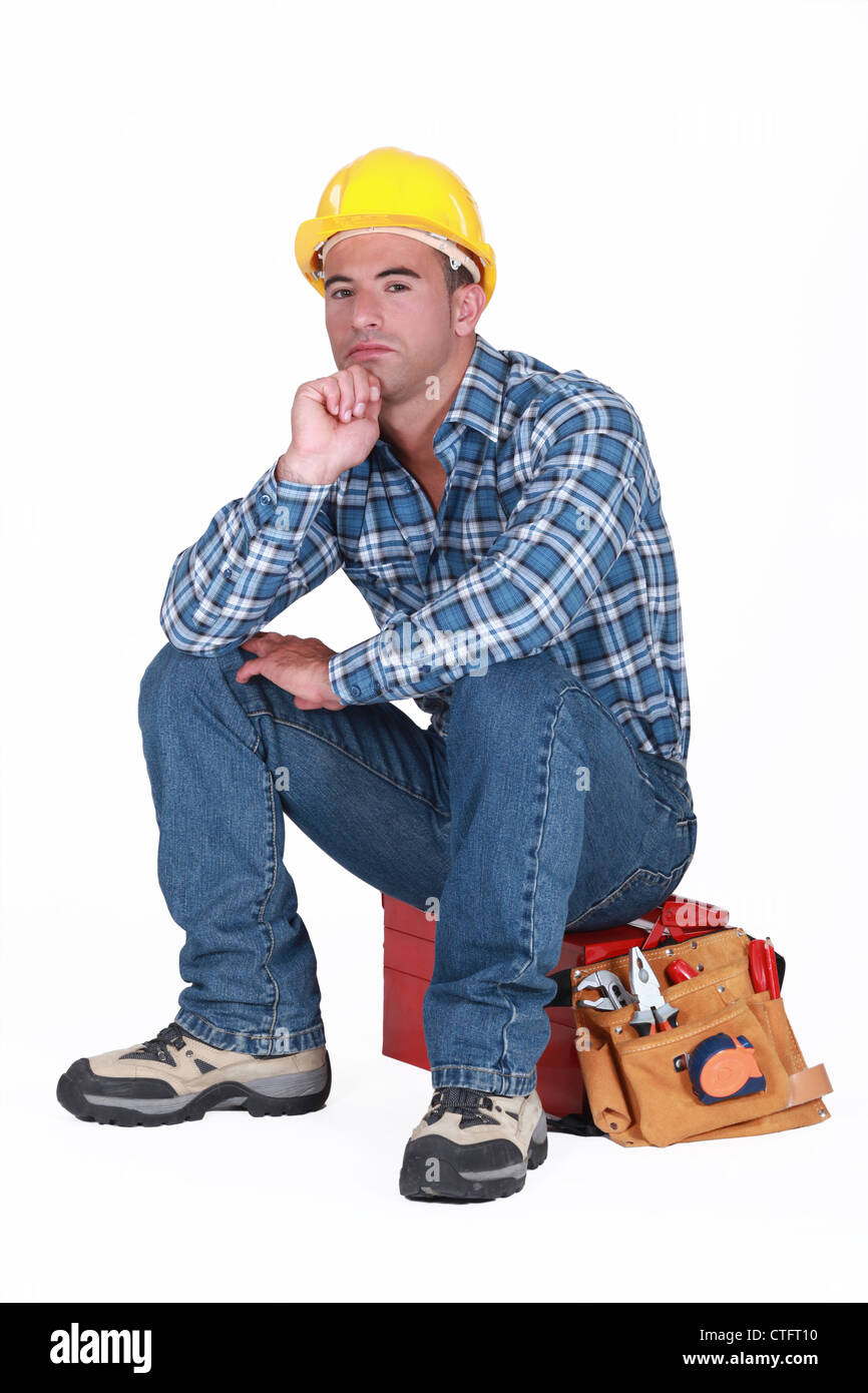 tradesman sitting on toolchest isolated on white Stock Photo - Alamy