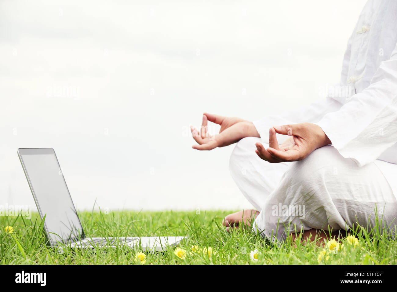 Man sitting in meditative lotus position with notebook on meadow Stock ...