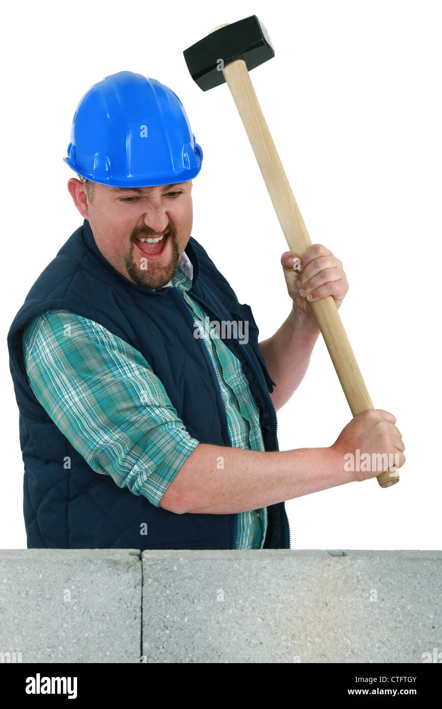 Man about to smash a wall using a mallet Stock Photo - Alamy