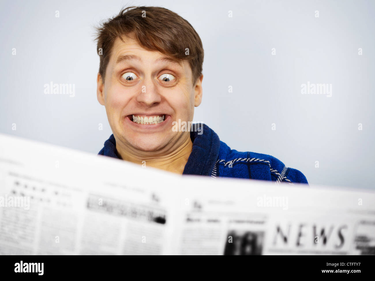 Man shocked while reading the news from newspapers Stock Photo - Alamy