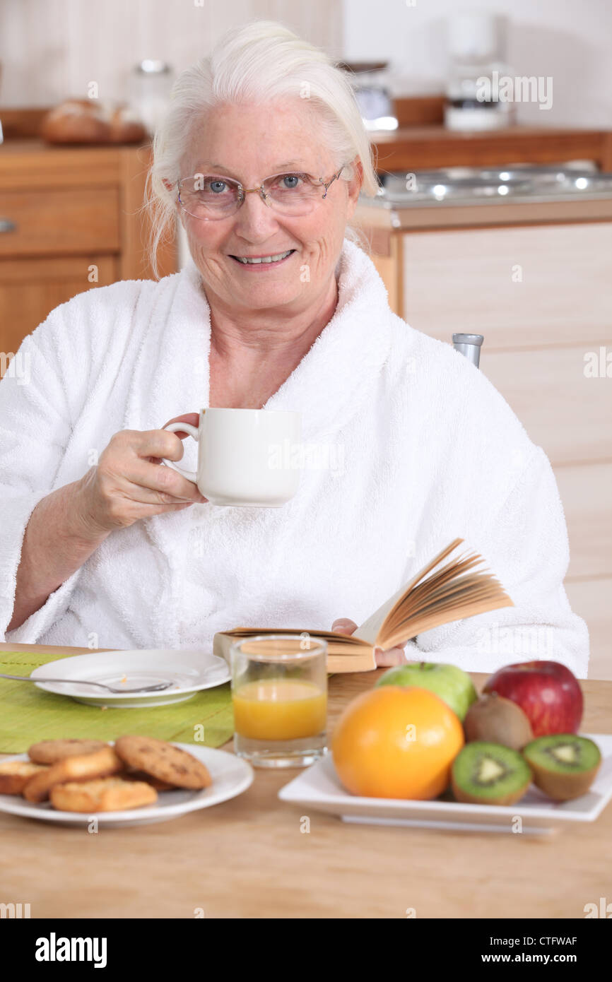 Senior woman having a relaxed breakfast Stock Photo - Alamy