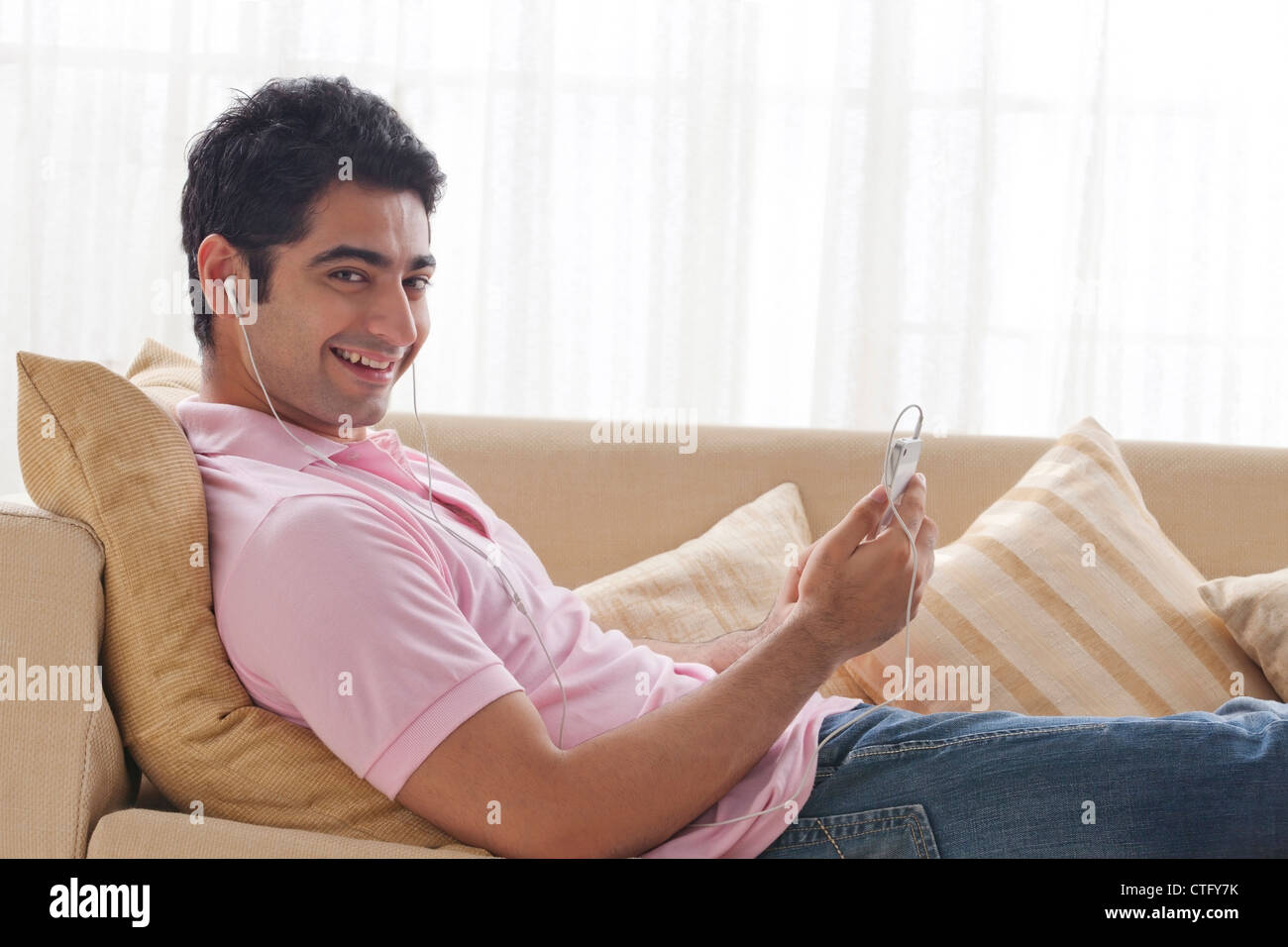 Portrait of handsome young man relaxing while listening to music Stock ...