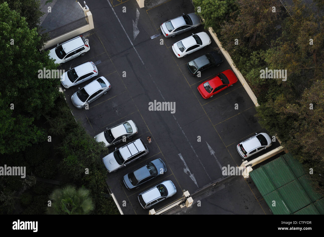 Aerial view of car park, various cars, man opening rear of car, boot ...