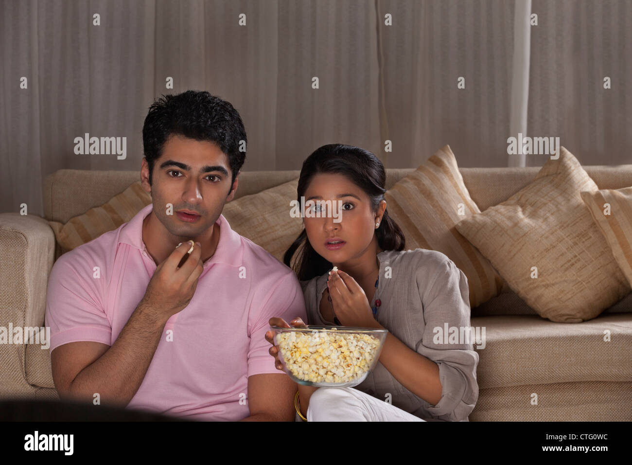 Young scared couple watching movie together at home Stock Photo - Alamy