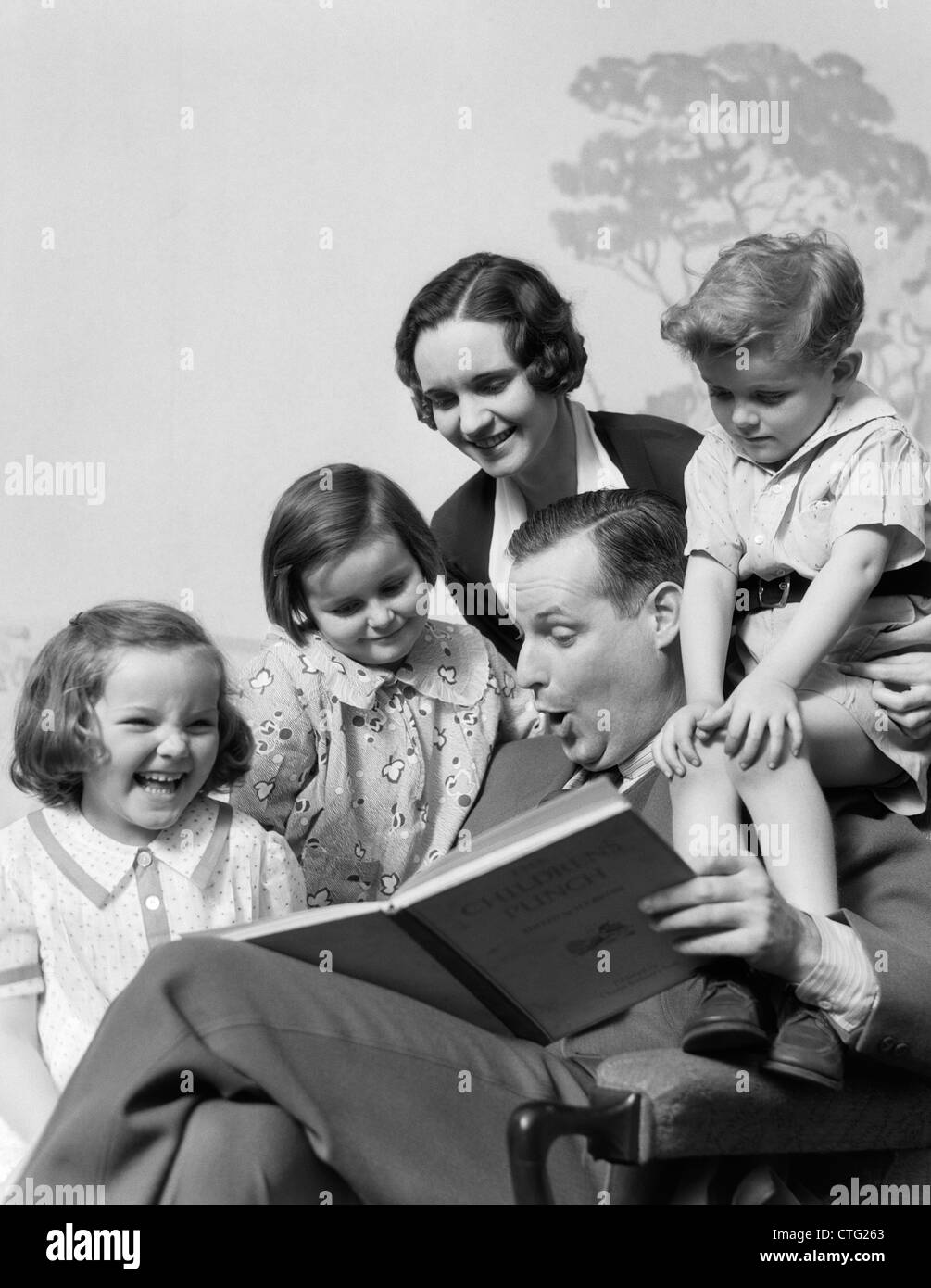 1930s FAMILY OF FIVE GROUPED AROUND FATHER READING CHILDREN'S PUNCH ...