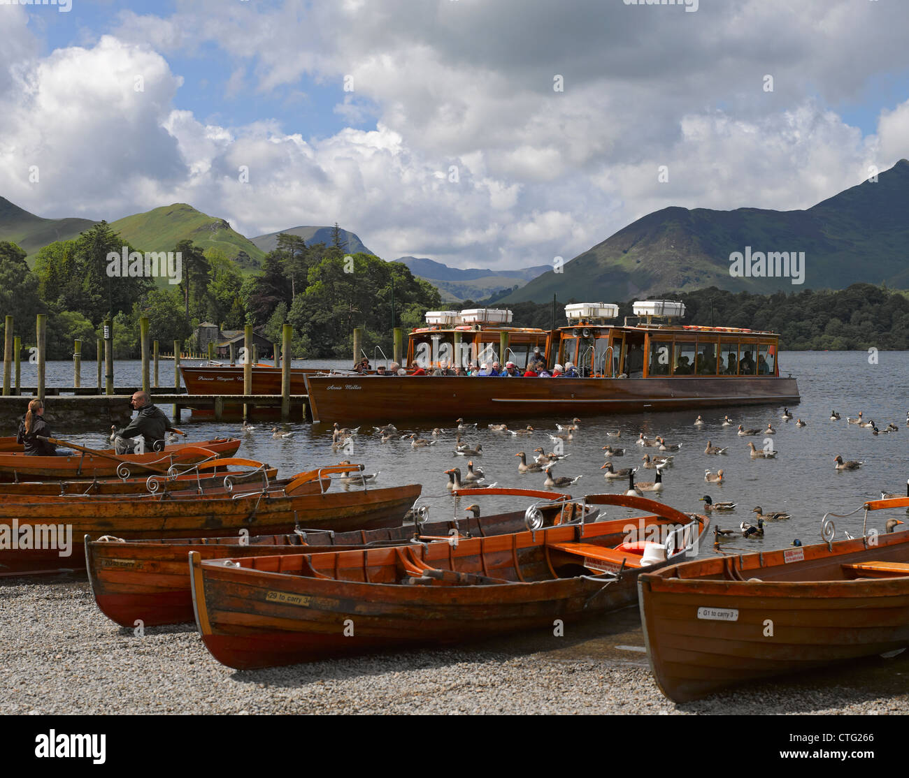 Launch and rowing boats boat lined up on the shoreline of Derwentwater ...