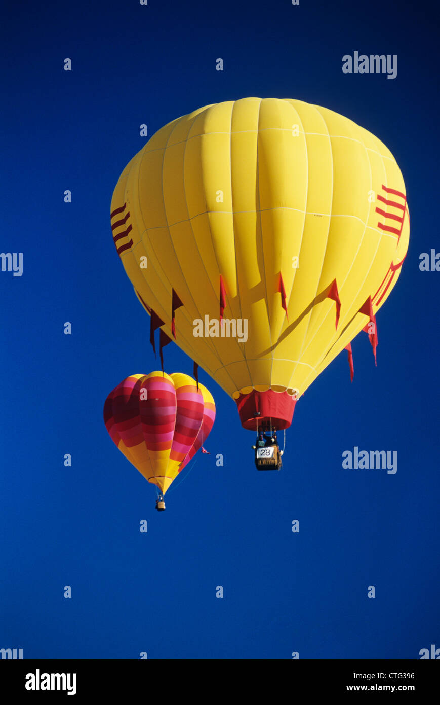 1990s RED AND YELLOW HOT AIR BALLOONS IN BLUE CLOUDLESS SKY Stock Photo ...
