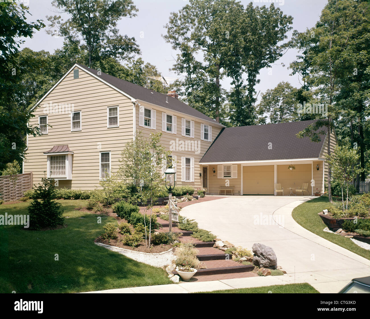 1970s TWO STORY YELLOW HOUSE WHITE SHUTTERS WITH TWO CAR GARAGE CURVED ...