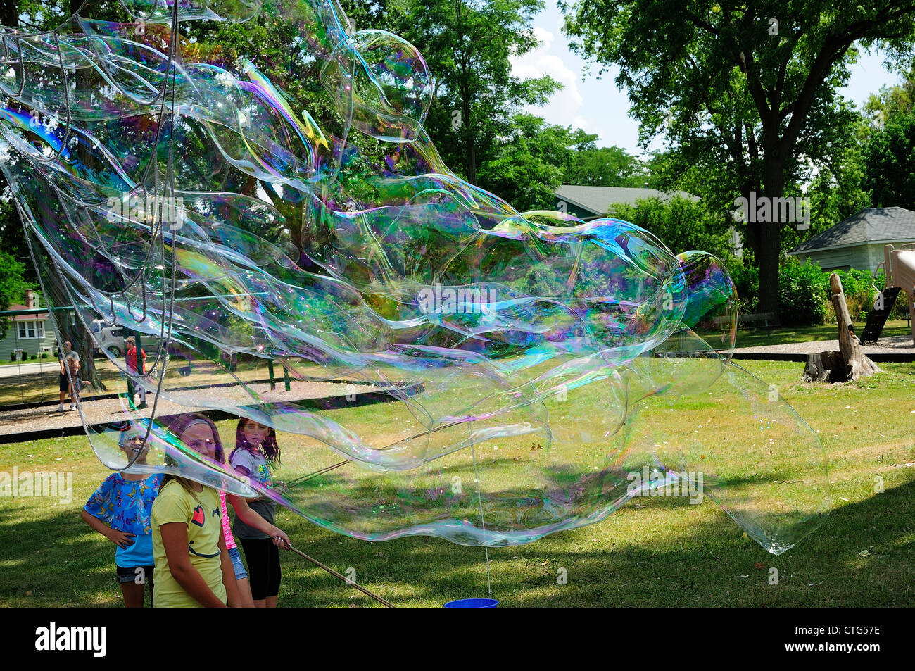 Kids blowing huge wind-blown bubbles at park festival Stock Photo - Alamy