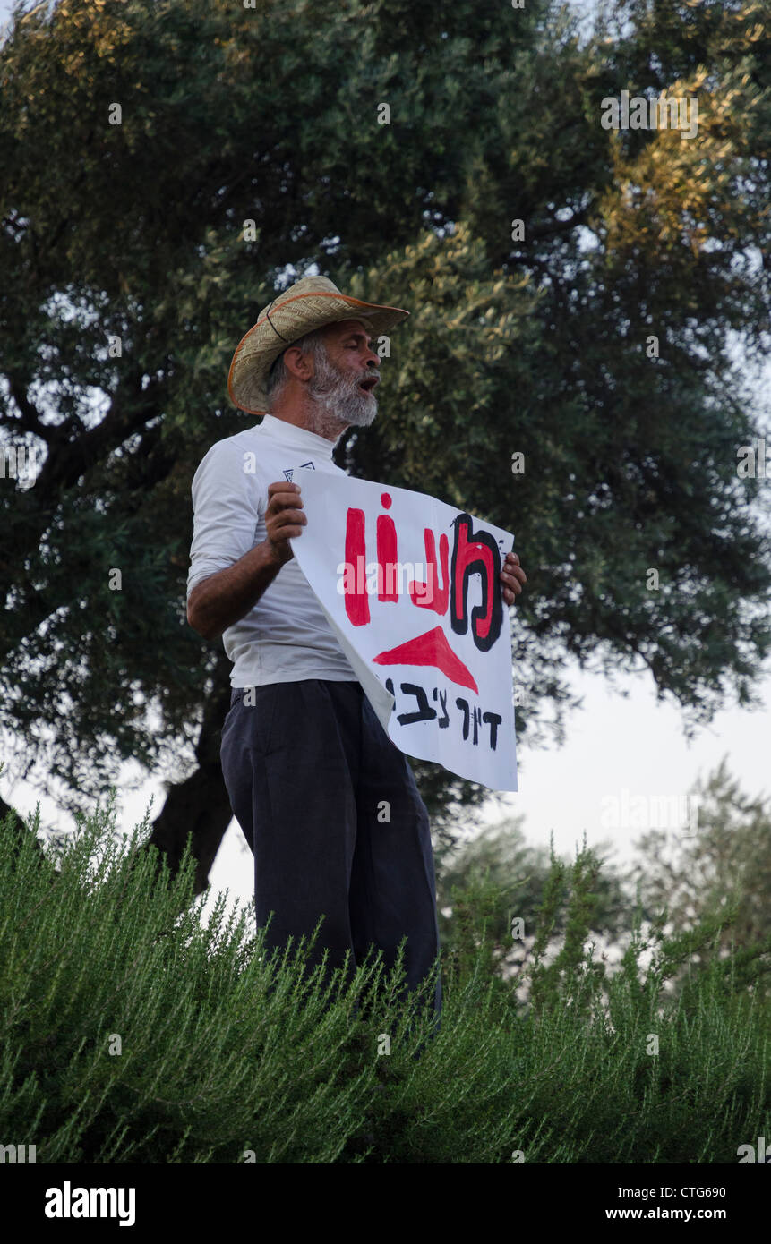 single protester holding a bill at social demonstration. Public garden ...