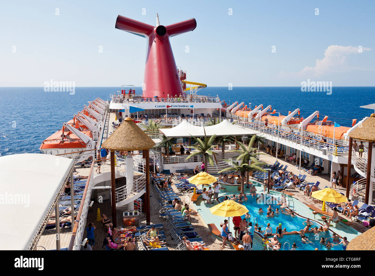 Cruise passengers enjoying the sun on deck of Carnival Fascination ...