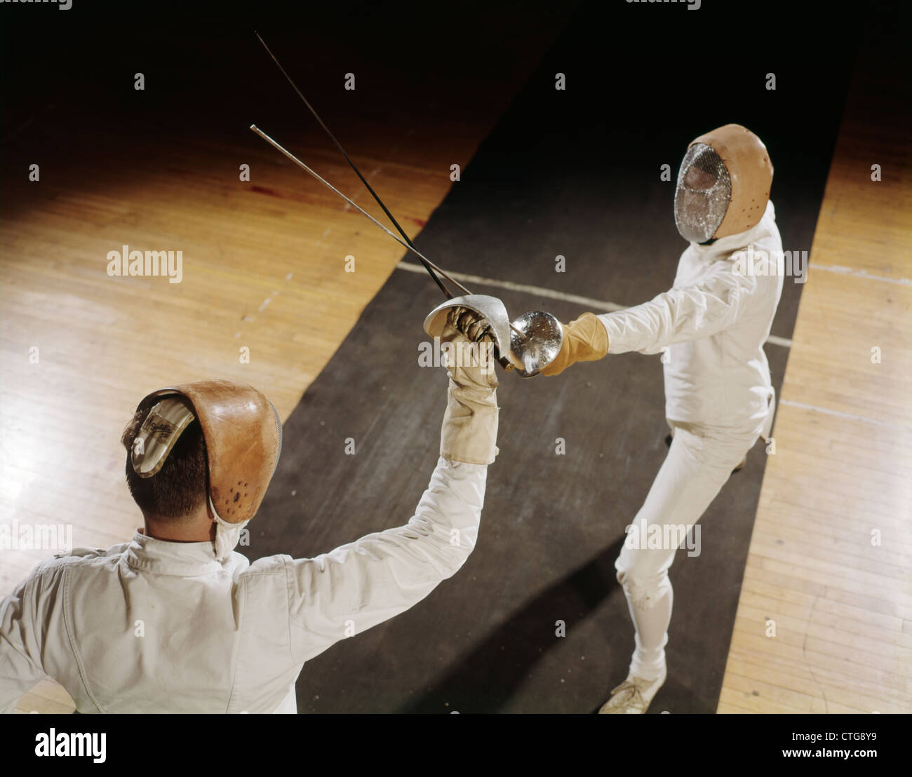 1960s TWO MEN FENCING PROTECTIVE SUITS MASK SWORDS EPEES RETRO Stock ...