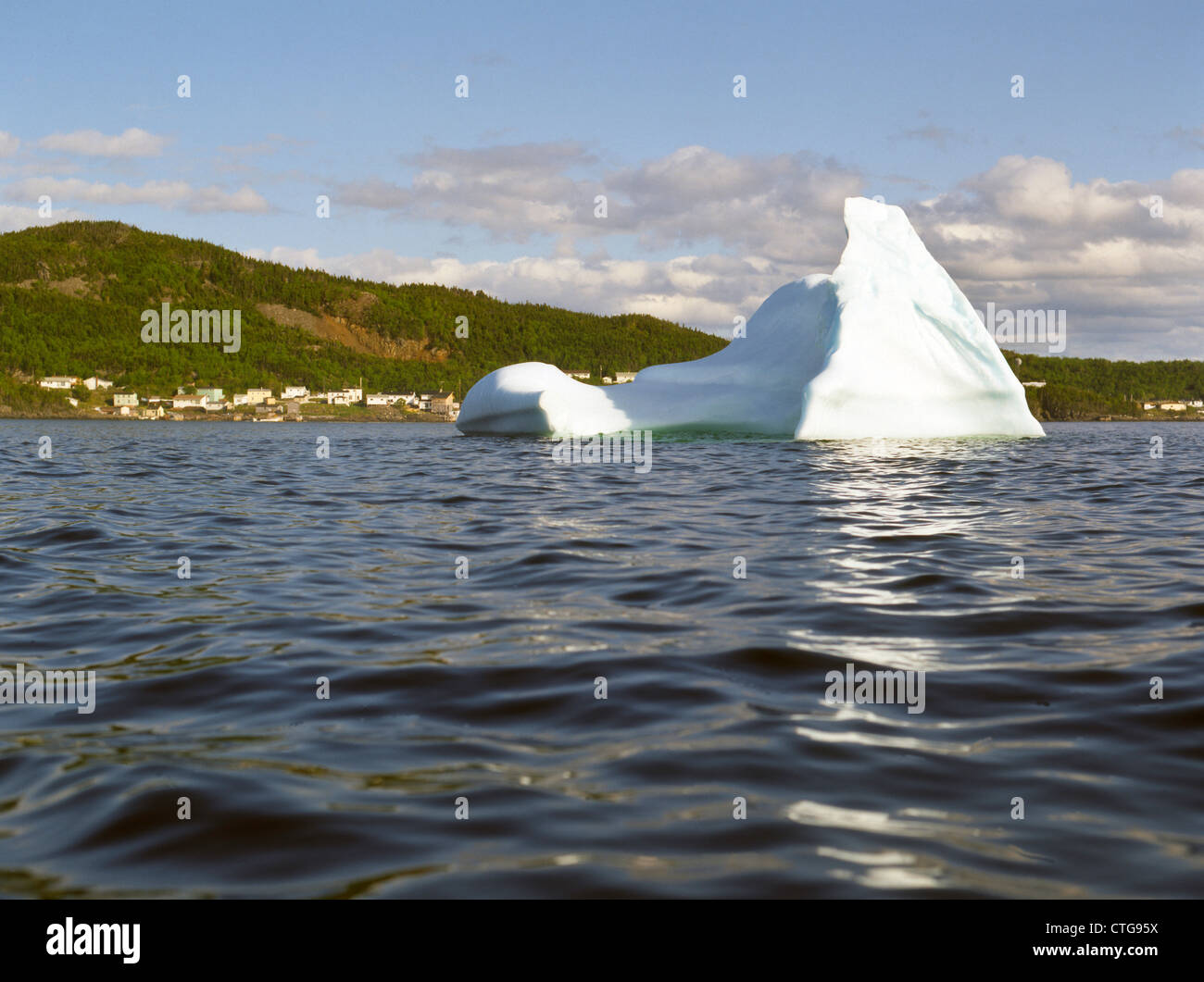 Iceberg in harbor of a fishing village in Newfoundland and Labrador in ...