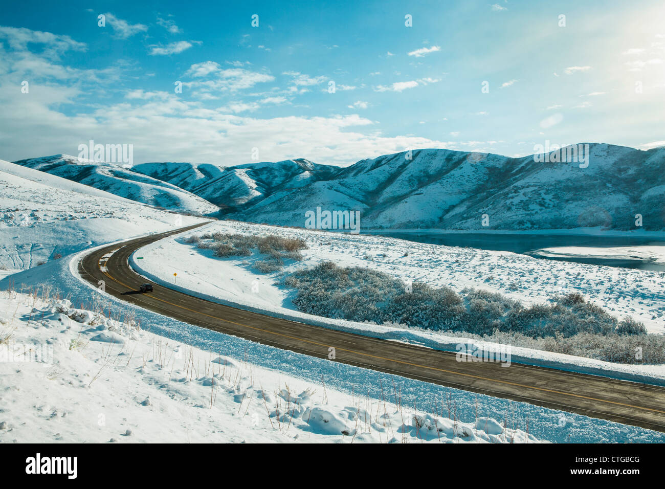 Road through snow covered valley Stock Photo - Alamy