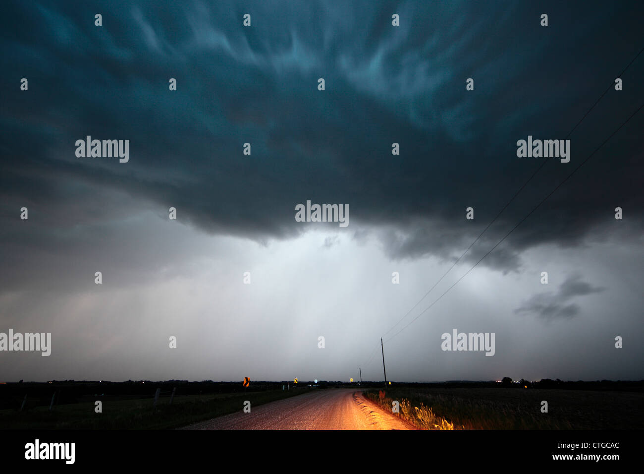 A squall line thunderstorm darkens the late afternoon sky over a ...