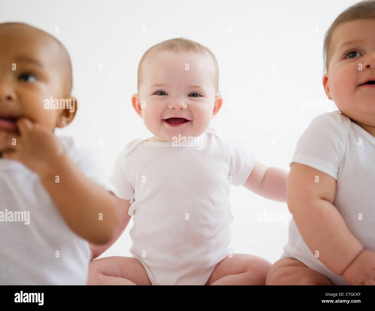 Smiling babies sitting together Stock Photo - Alamy