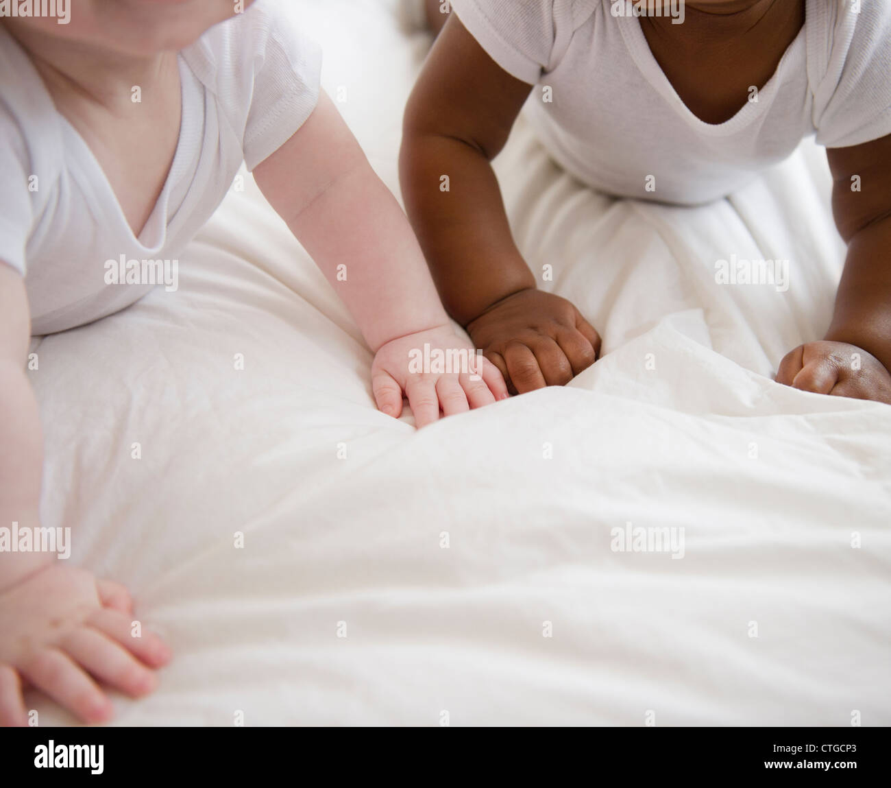 Babies laying on floor together Stock Photo - Alamy
