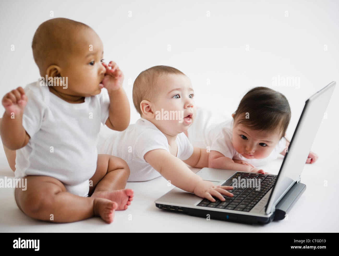 Babies playing with laptop Stock Photo - Alamy