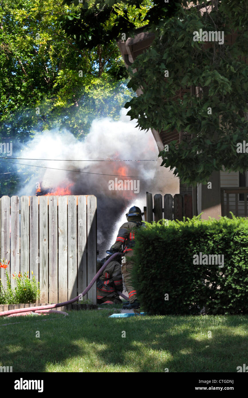 Firefighters extinguish a residential neighborhood garage fire with ...