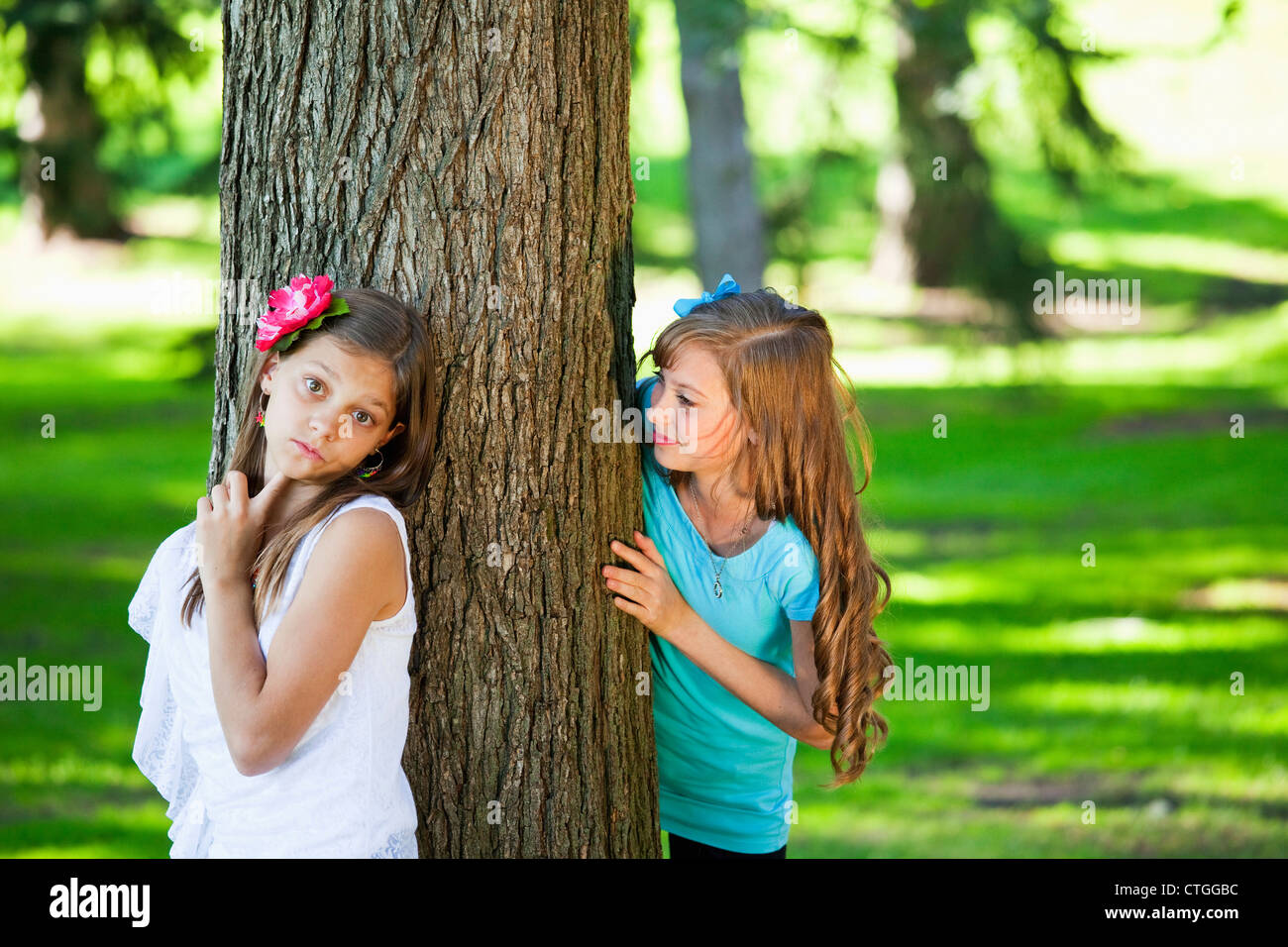 Two Sisters Playing Hide And Seek In A Park; Edmonton, Alberta, Canada ...