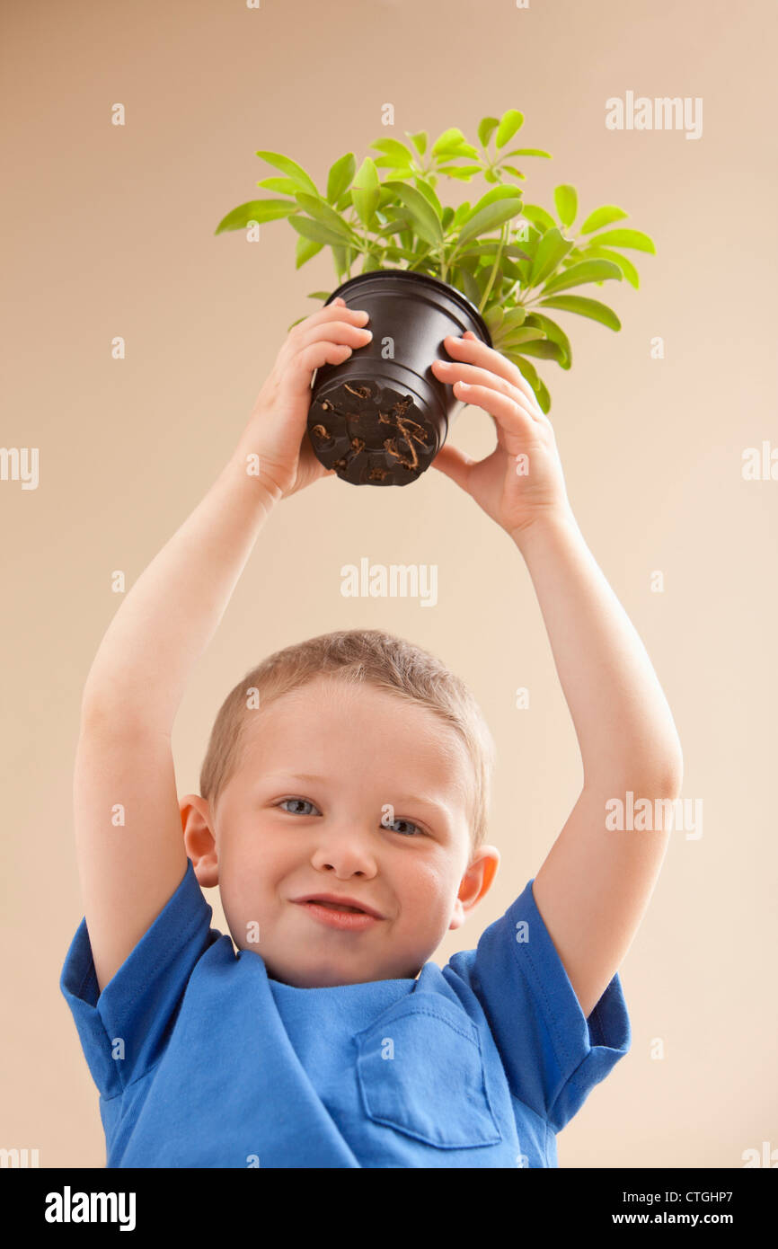 Caucasian boy holding potted plant Stock Photo - Alamy