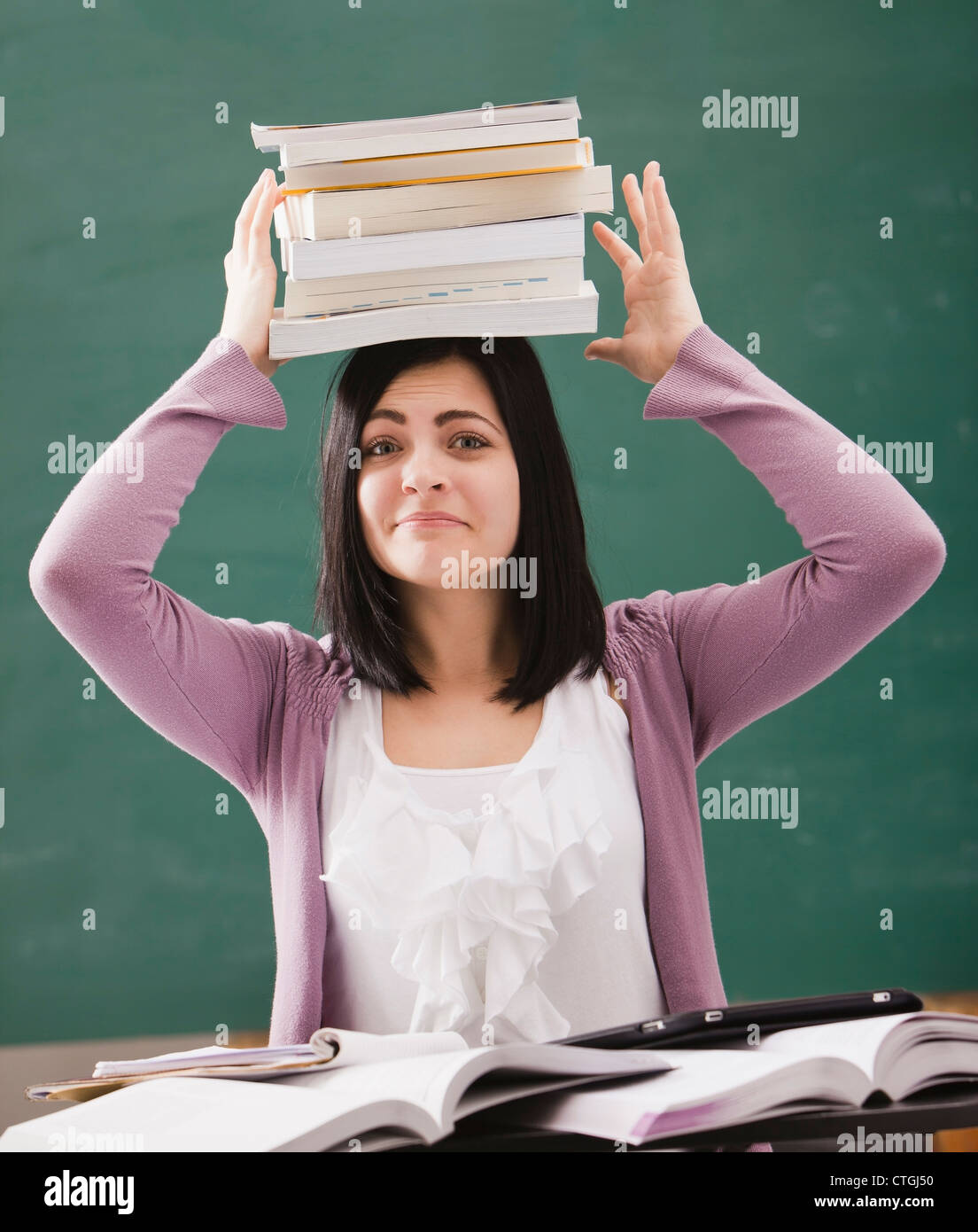 Caucasian student balancing books on head Stock Photo - Alamy