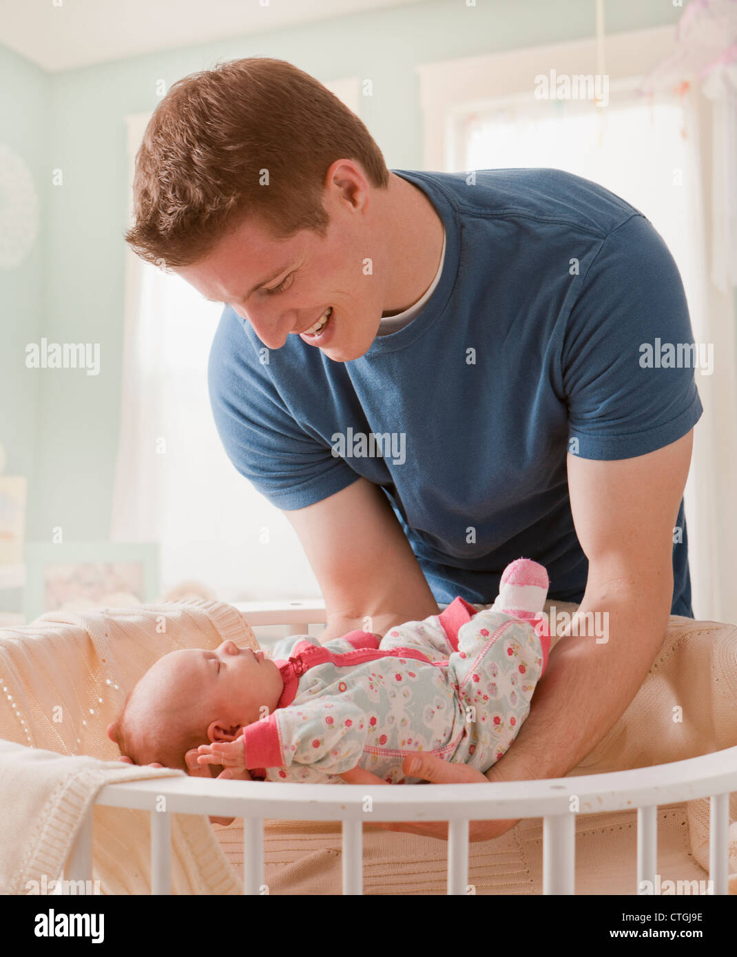 Caucasian father lifting baby girl from crib Stock Photo - Alamy