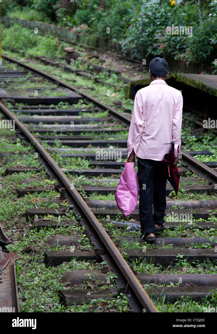 man walking on railway tracks in Sri Lanka, in Central Hill Region ...