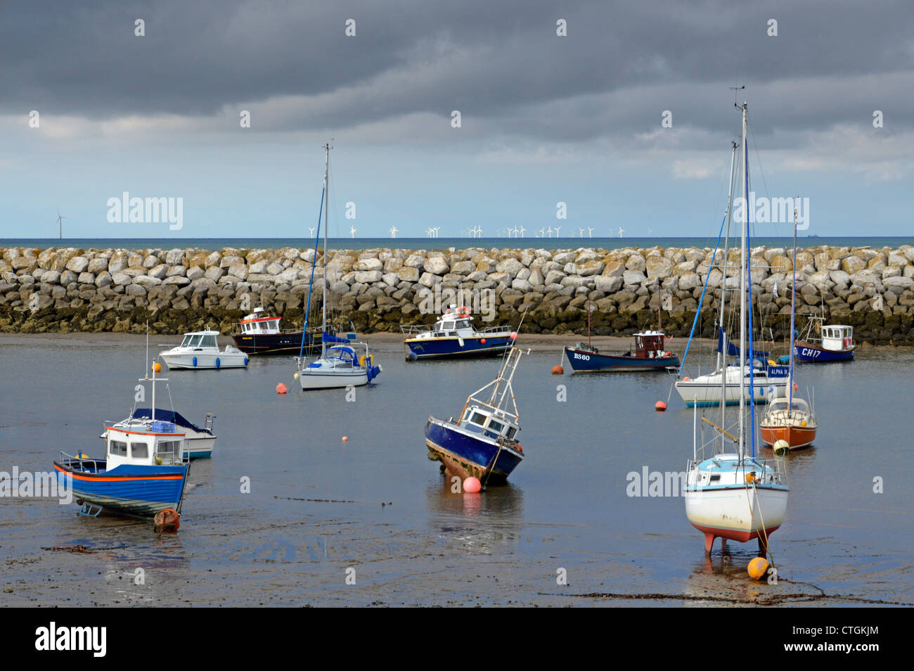 Sea defences breakwater forming a small harbour with off shore wind ...