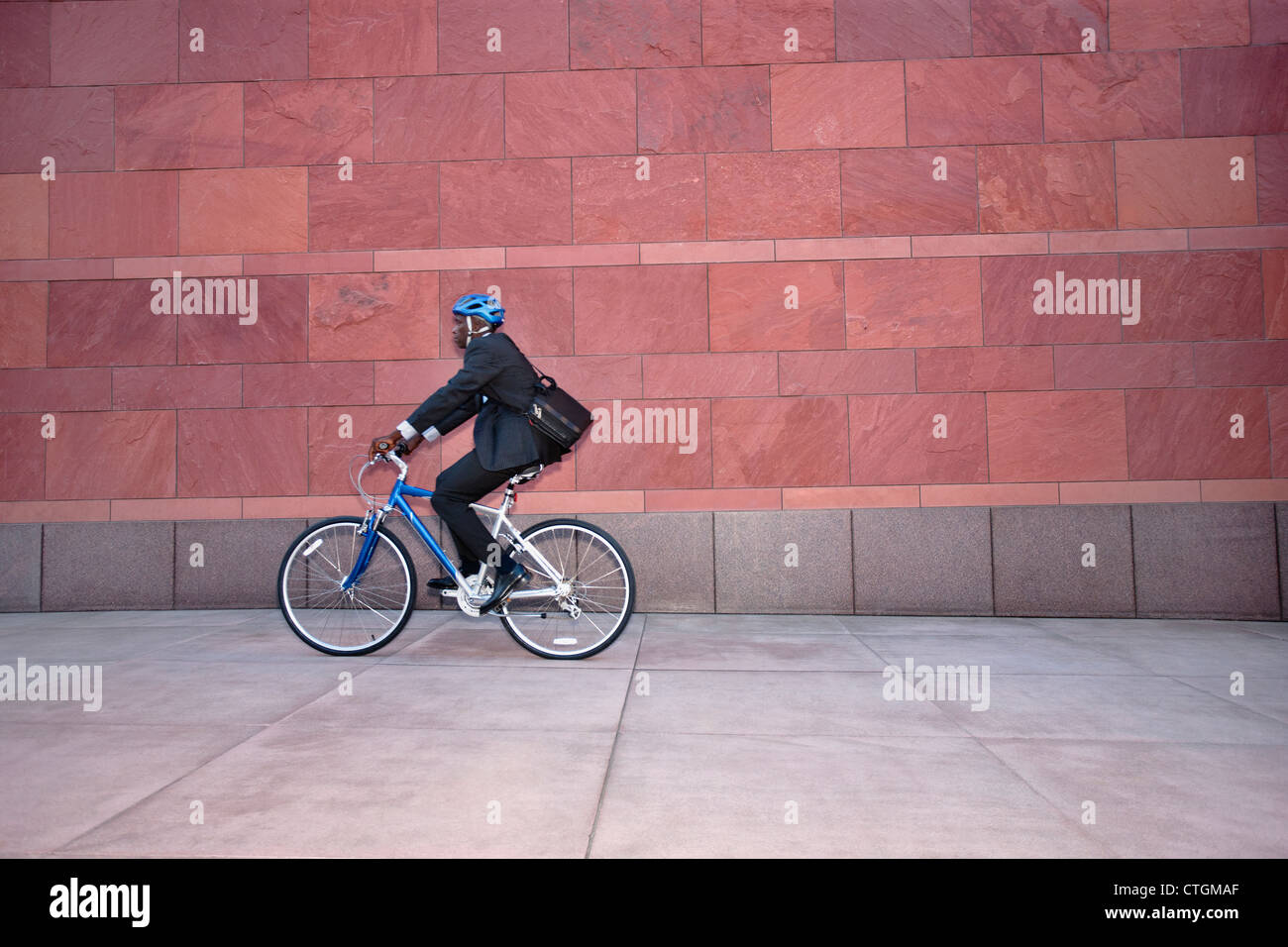 Businessman riding bicycle on sidewalk Stock Photo - Alamy