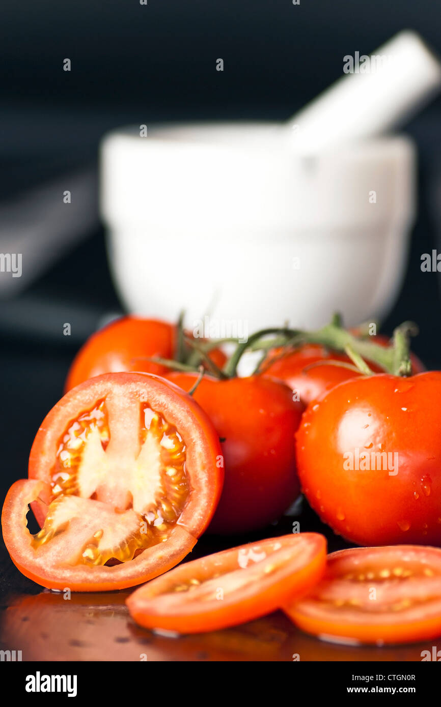Close-up of the cross section of one sliced tomatoes. With four whole ...