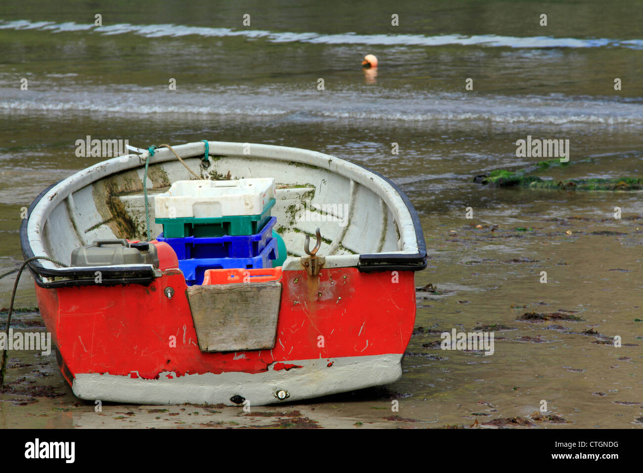 Small rowing boat sitting on a beach at low tide Stock Photo - Alamy