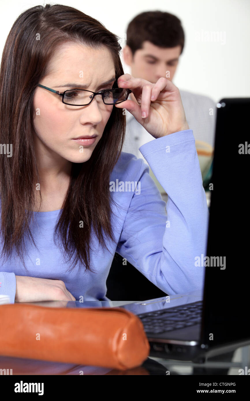 Confused female student looking at laptop screen Stock Photo - Alamy