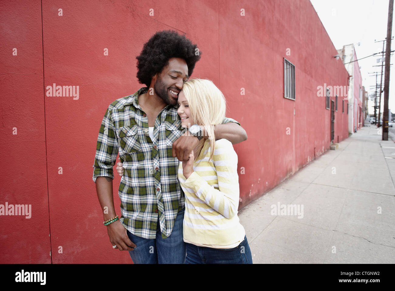 Couple hugging on urban sidewalk Stock Photo - Alamy
