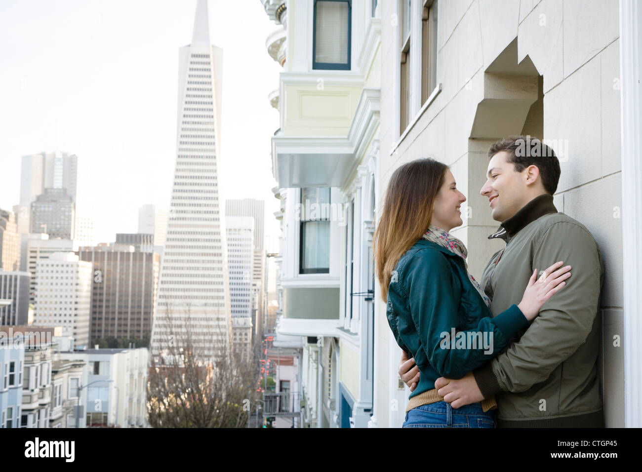 Caucasian couple hugging in city Stock Photo - Alamy