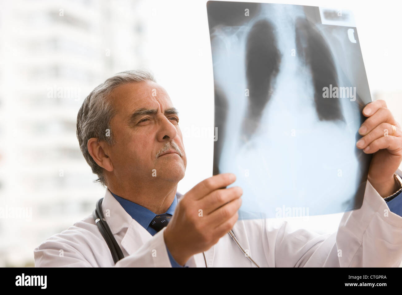 Hispanic doctor looking at x-ray Stock Photo - Alamy