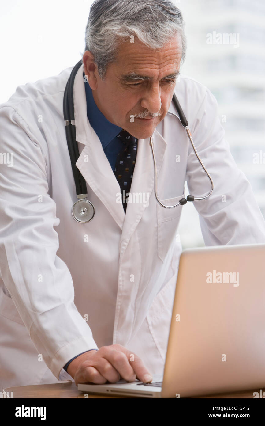 Hispanic doctor using laptop Stock Photo - Alamy