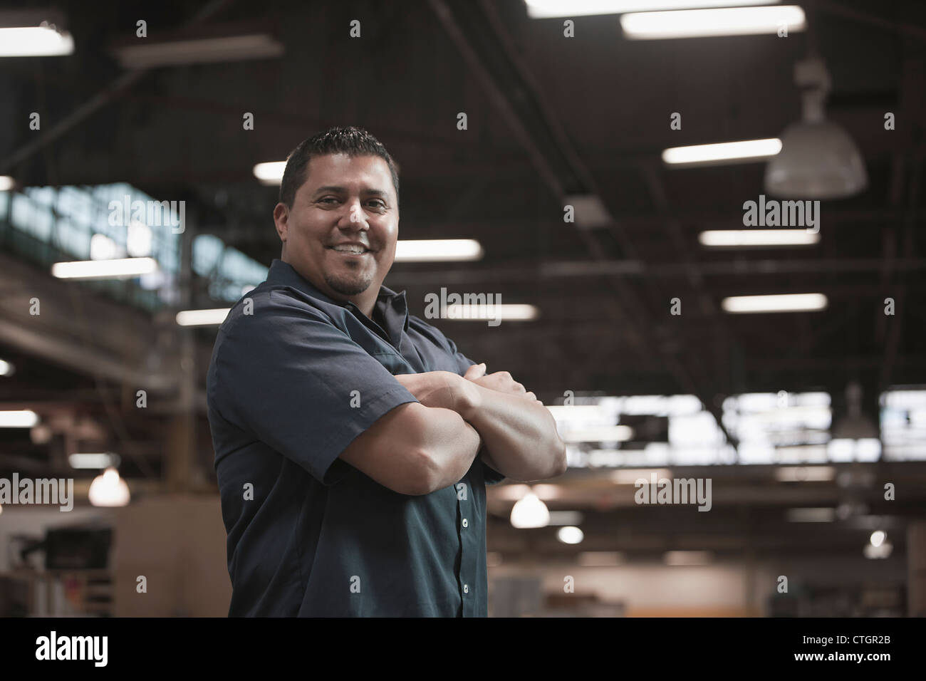Hispanic worker standing in warehouse Stock Photo - Alamy
