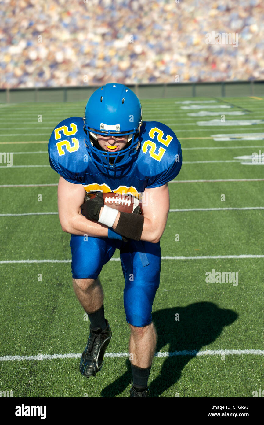 Caucasian football player running with ball Stock Photo - Alamy