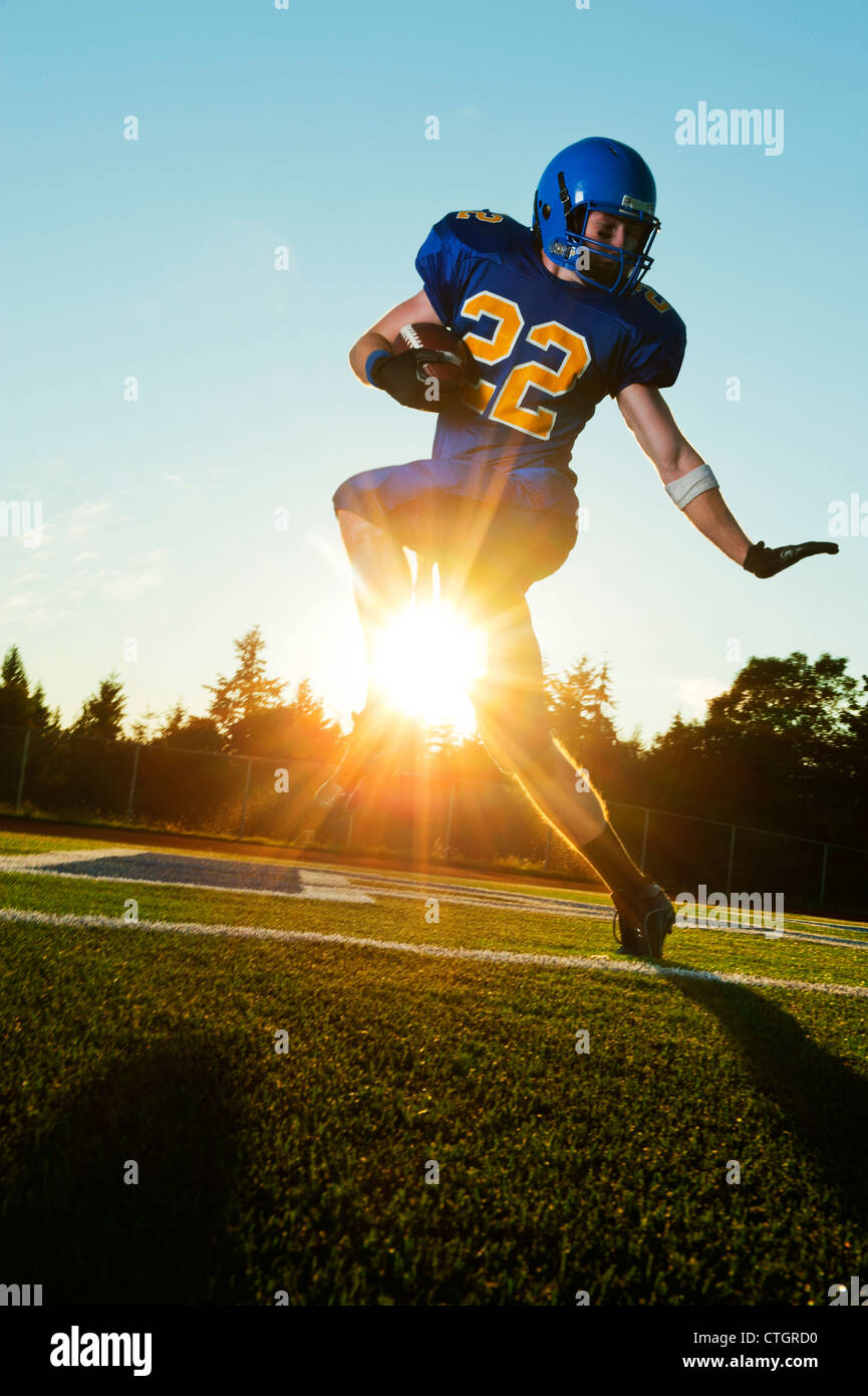 Caucasian football player running with ball Stock Photo - Alamy