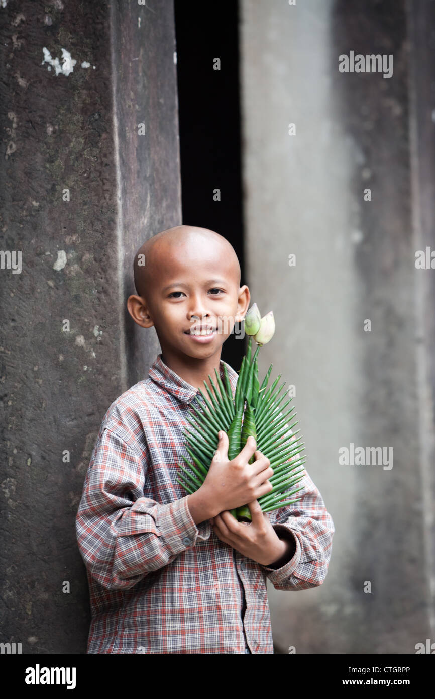 SIEM REAP, CAMBODIA - A young Buddhist boy sells flowers to tourists ...