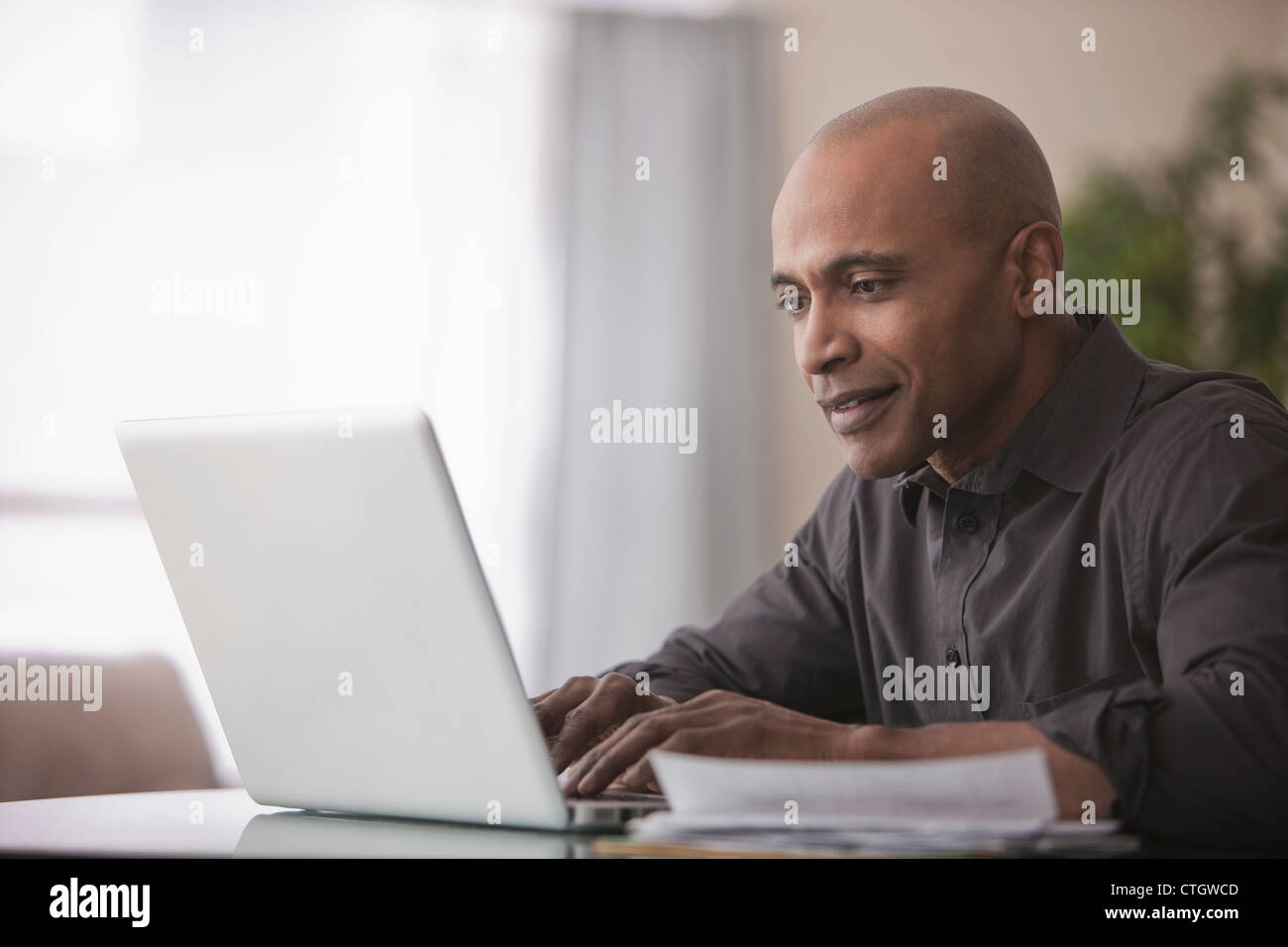 Black man typing on laptop Stock Photo - Alamy