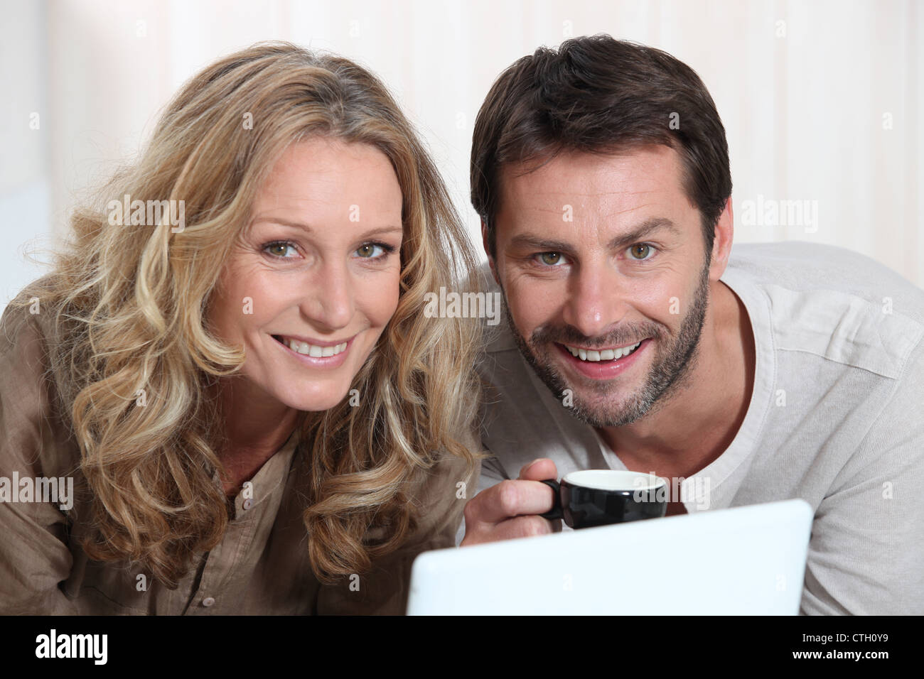 Couple smiling on laptop Stock Photo - Alamy