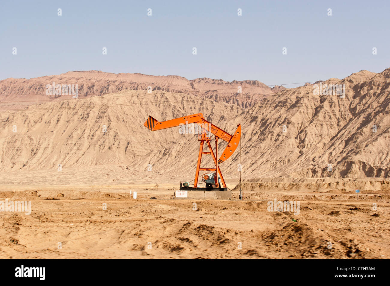 A nodding donkey pump jack, or pumping unit is seen in the desert with ...
