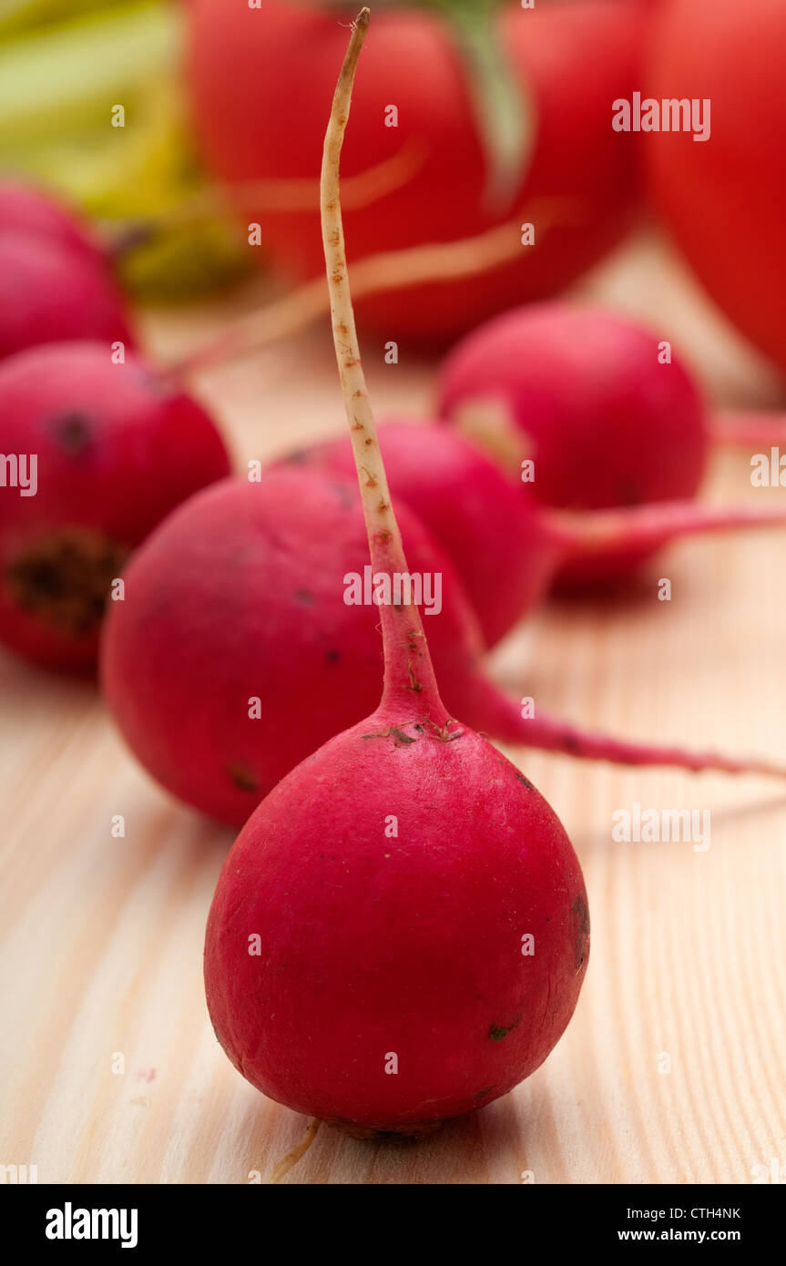 fresh raddish and vegetables over pine wood table closeup Stock Photo ...