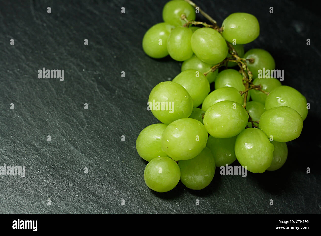 Fresh green grapes on a dark slate Stock Photo - Alamy