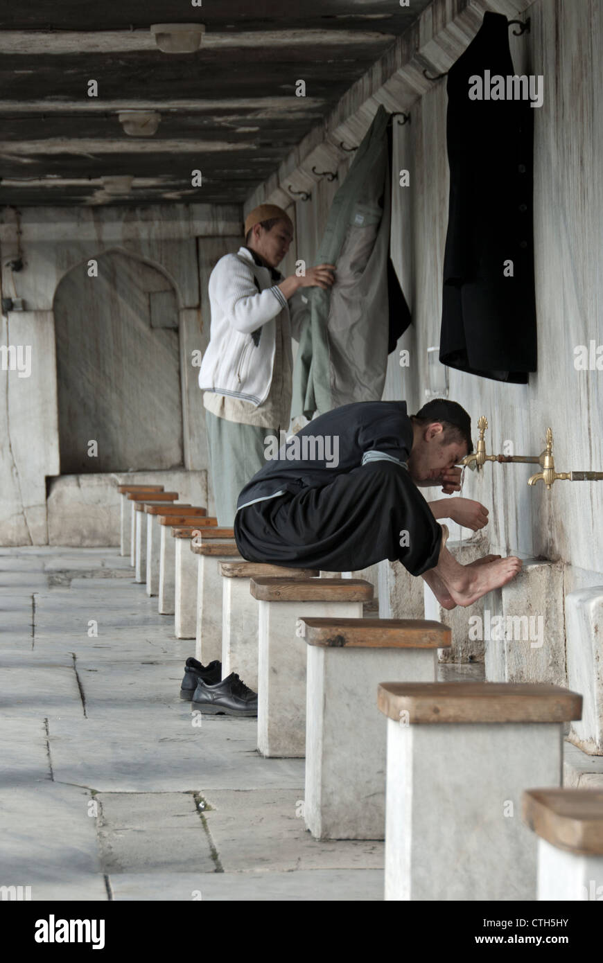 Young Muslim man performing ablution ritual before praying at the Blue ...