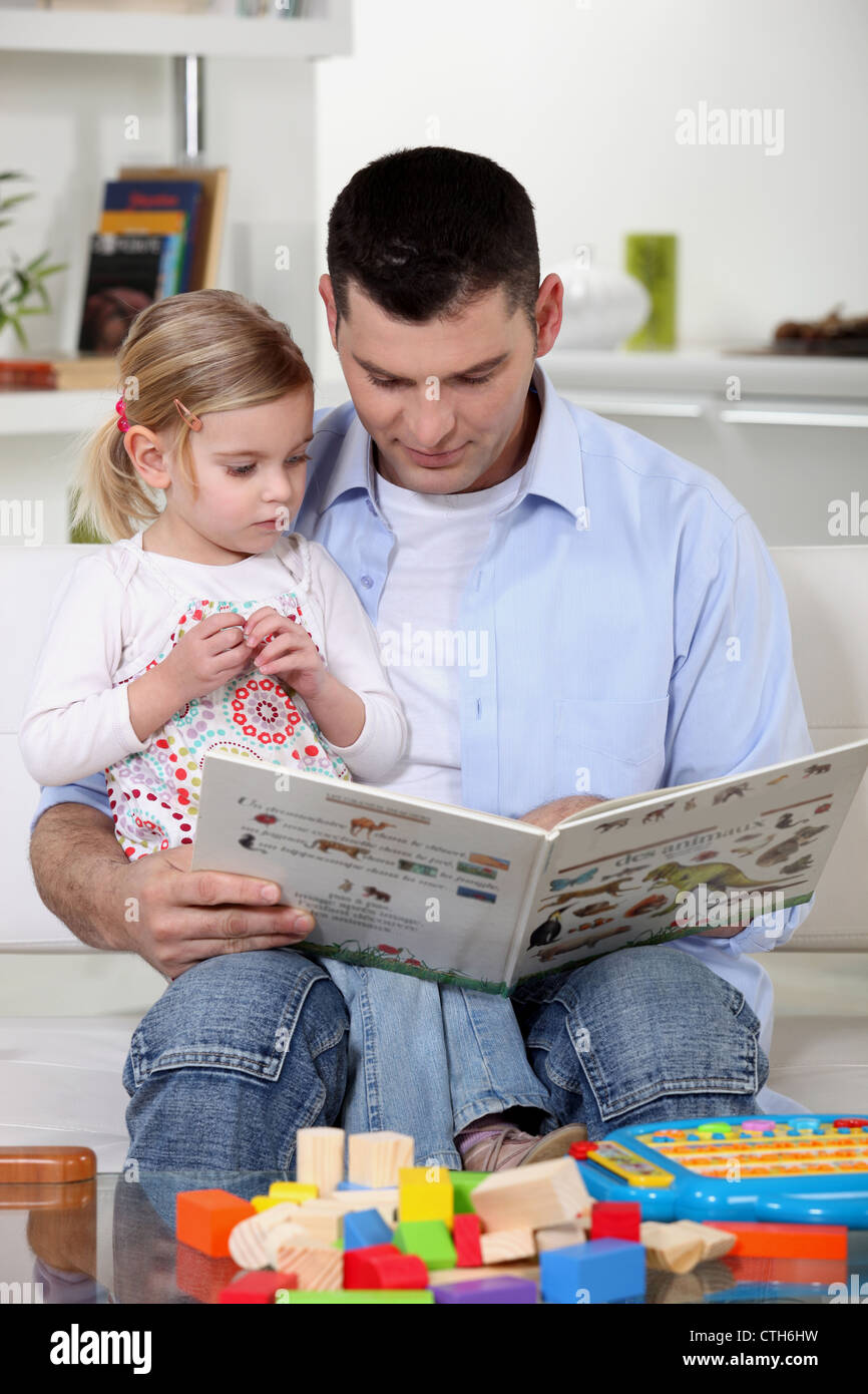 father reading a book to his little girl Stock Photo - Alamy