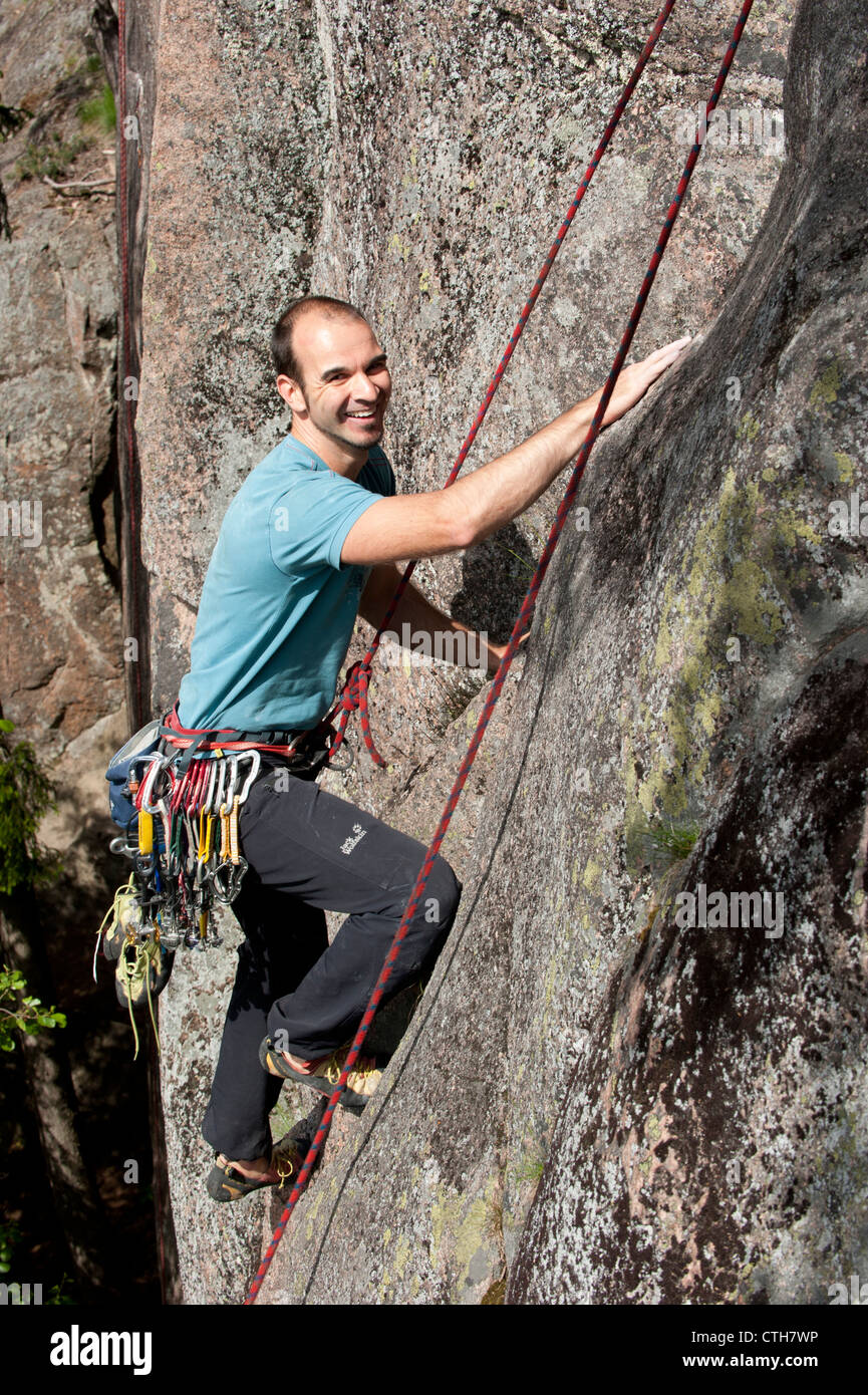 Climber climbing a rock wall Stock Photo - Alamy
